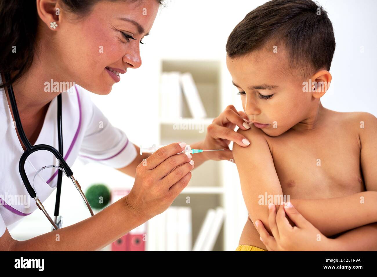 Gentle lady doctor giving a vaccine to one fearless little boy Stock ...