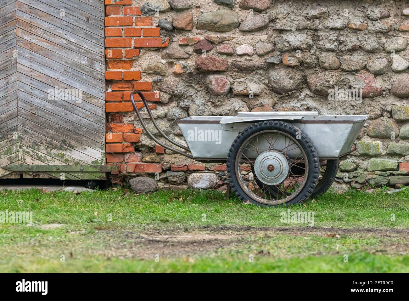 A homemade wheelbarrow stands at the door of the barn. Homemade ...