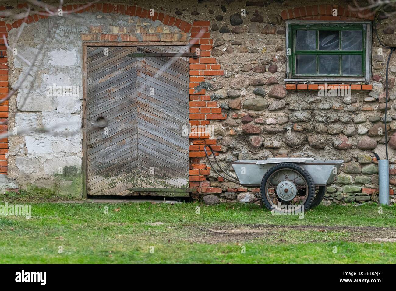A homemade wheelbarrow stands at the door of the barn. Homemade ...