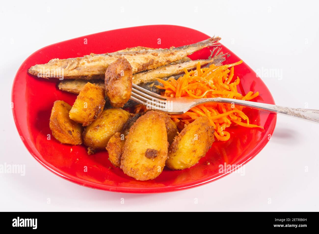 Homemade dish - fried potato wedges with small fish and pickled carrots ...