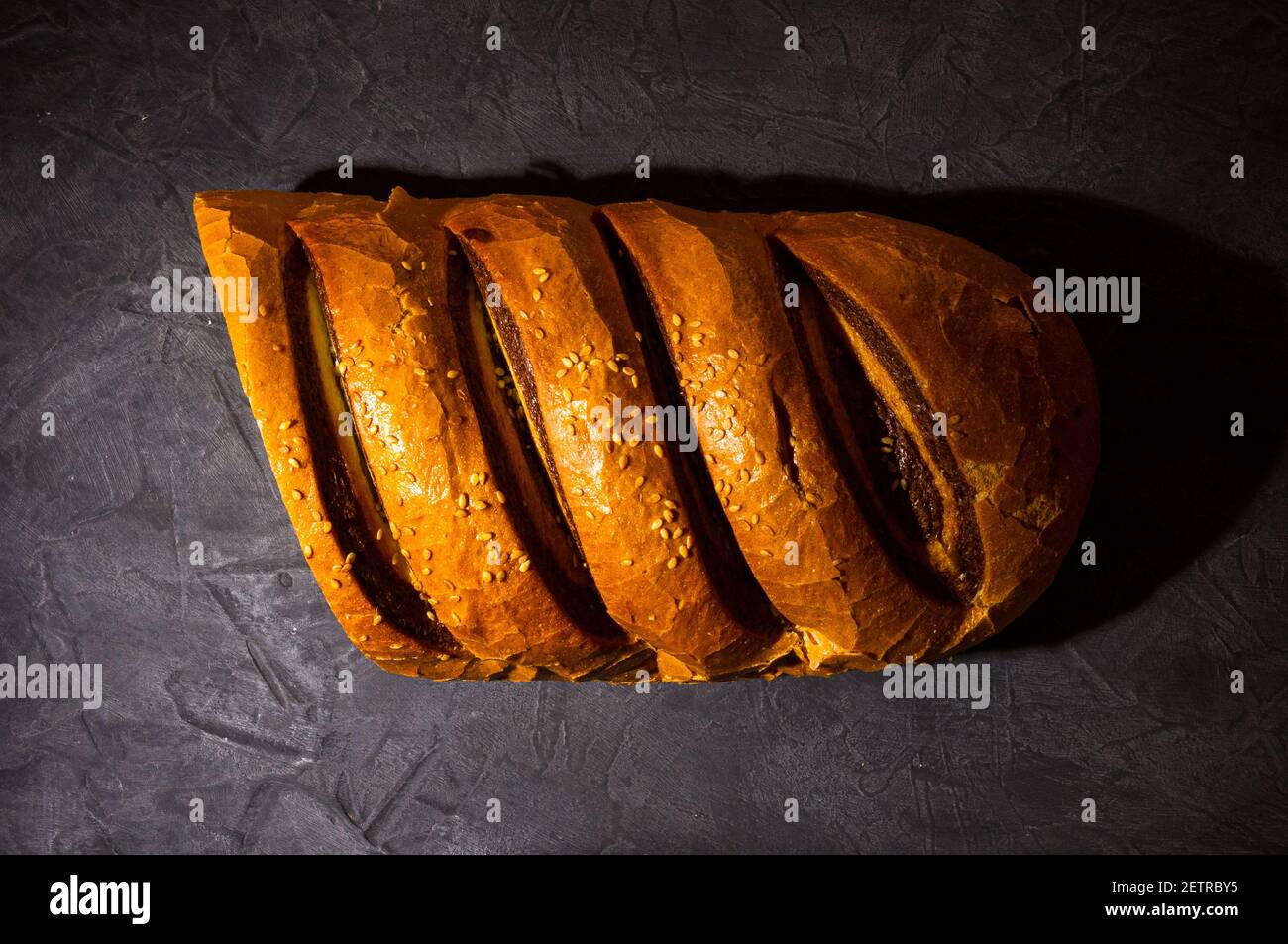 Unusual two-color fresh loaf of bread on a black background, photo in a ...