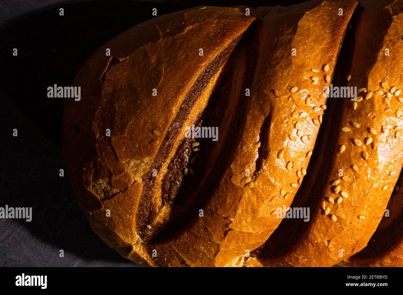 Unusual two-color fresh loaf of bread on a black background, photo in a ...