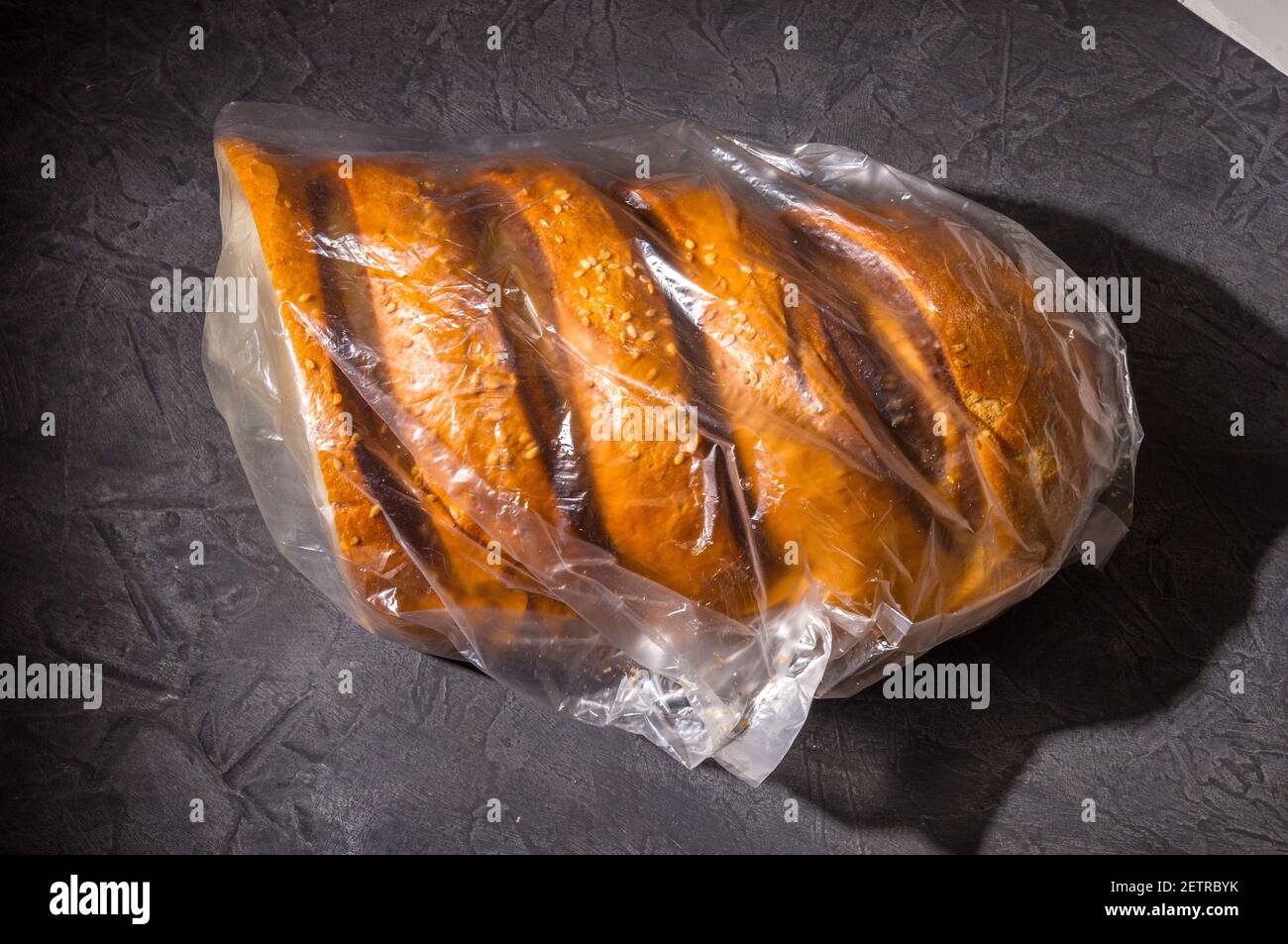 Unusual two-color fresh loaf of bread in a transparent plastic bag on a ...