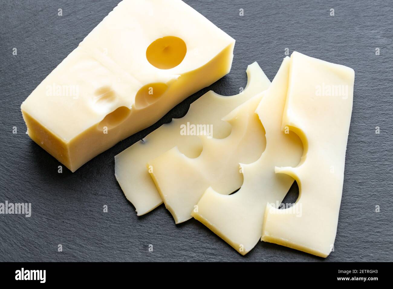 Gouda cheese slices on stone gray background Stock Photo - Alamy