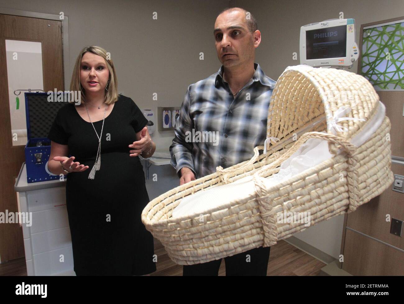 Erin and Tony Maroon hold a cooling bassinet, which is part of the ...