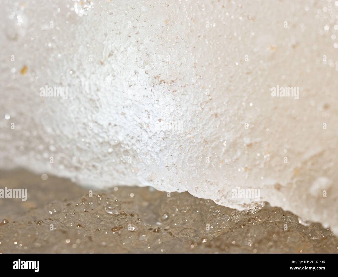 Melting piece of ice fallen into water. Structure of natural ice caught ...
