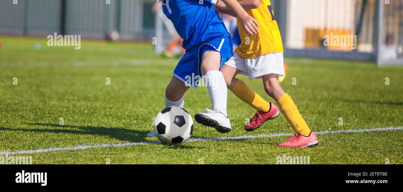 Football Players Compete For a Ball. Children Playing Sports on Grass ...