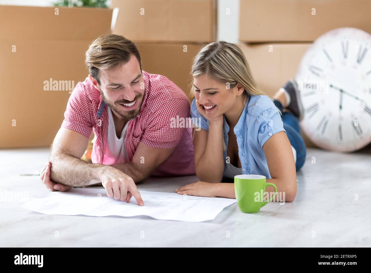 Young smiling couple making a plan about there new home Stock Photo - Alamy
