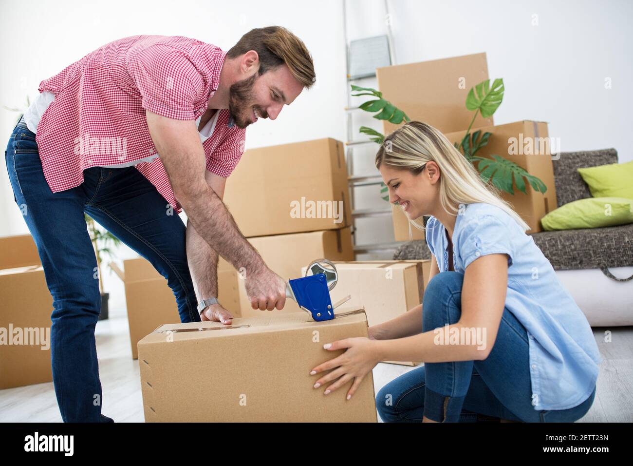 Young couple packing things in boxes for moving in new house Stock ...