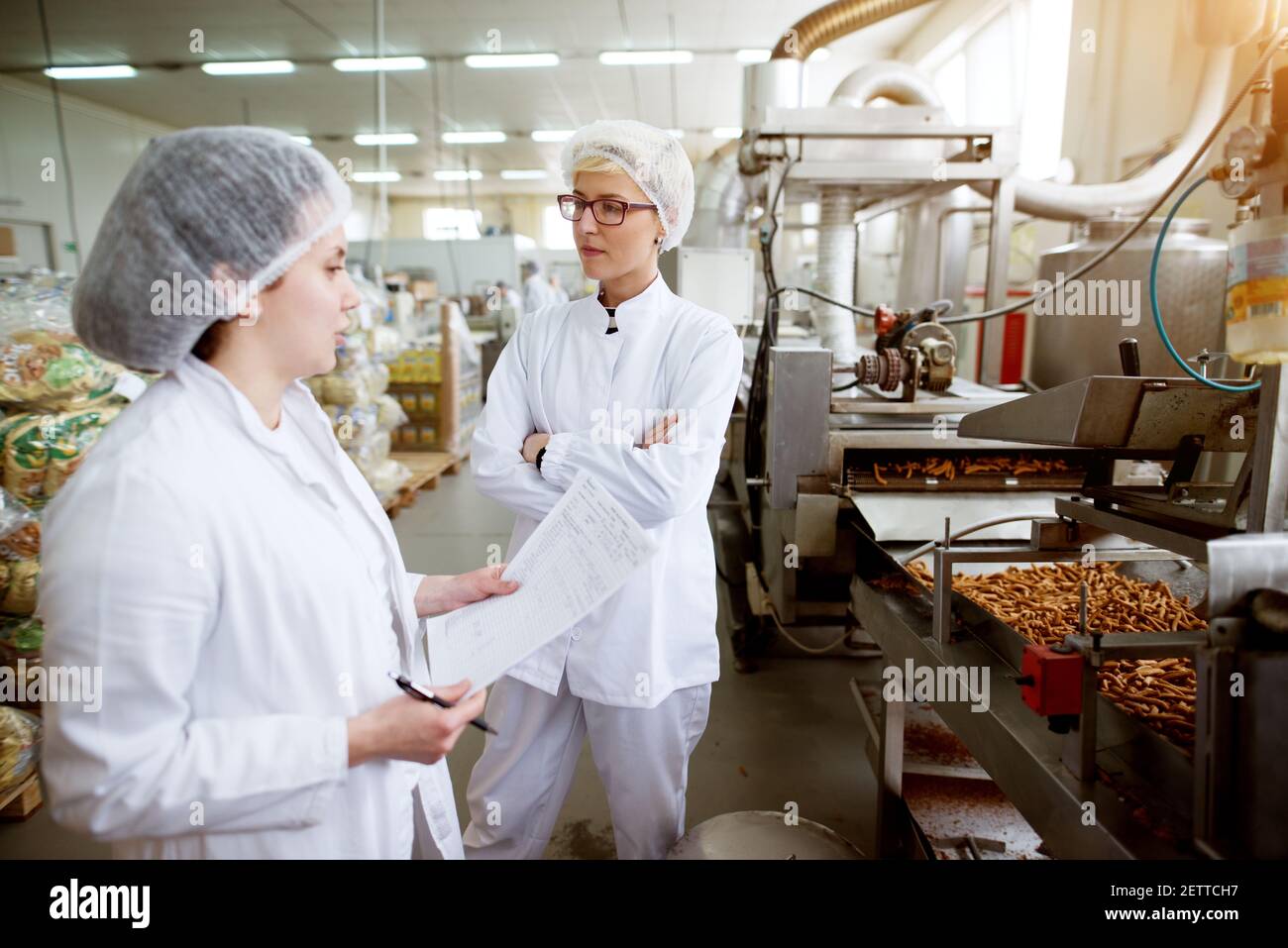 Focused dedicated tired female employee giving rapport in food ...