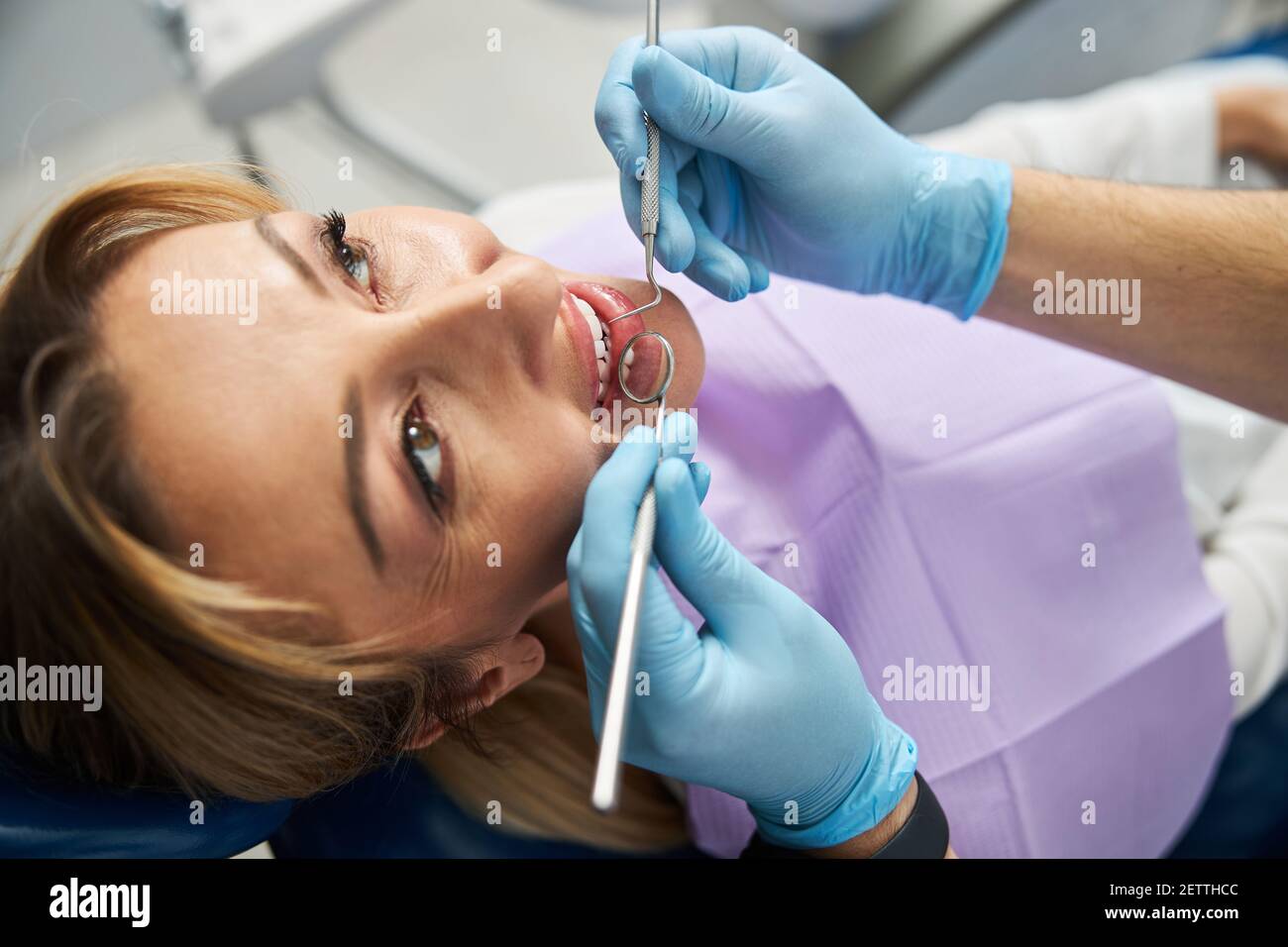 Dental mirror and explorer in a female mouth Stock Photo - Alamy