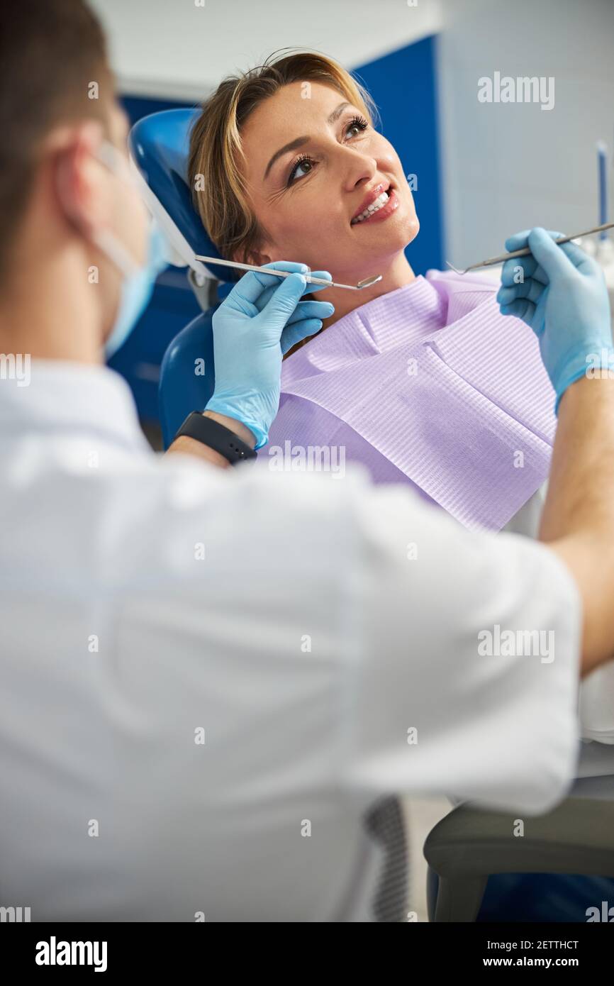 Dentist moving dental probe and mirror to woman teeth Stock Photo - Alamy