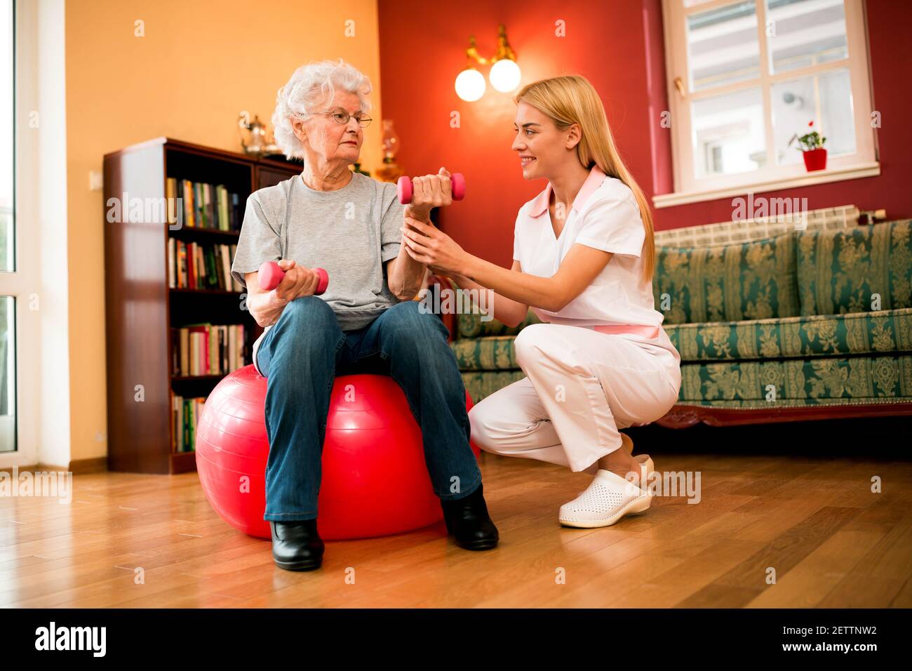 Senior woman workout with dumbbells, nurse helps to patient about ...
