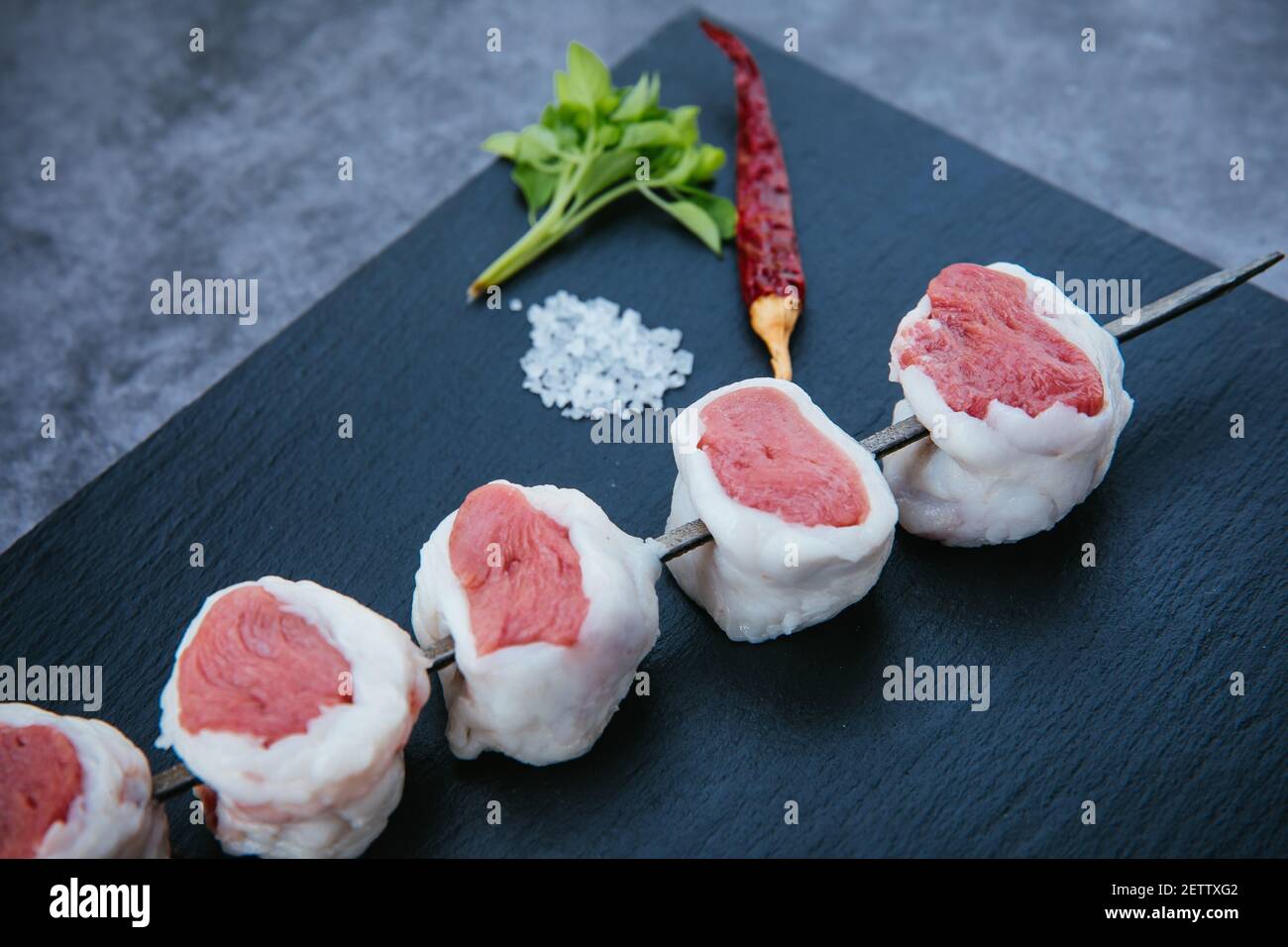 Raw and fresh beef meat steaks on the black background. Skewers of ...