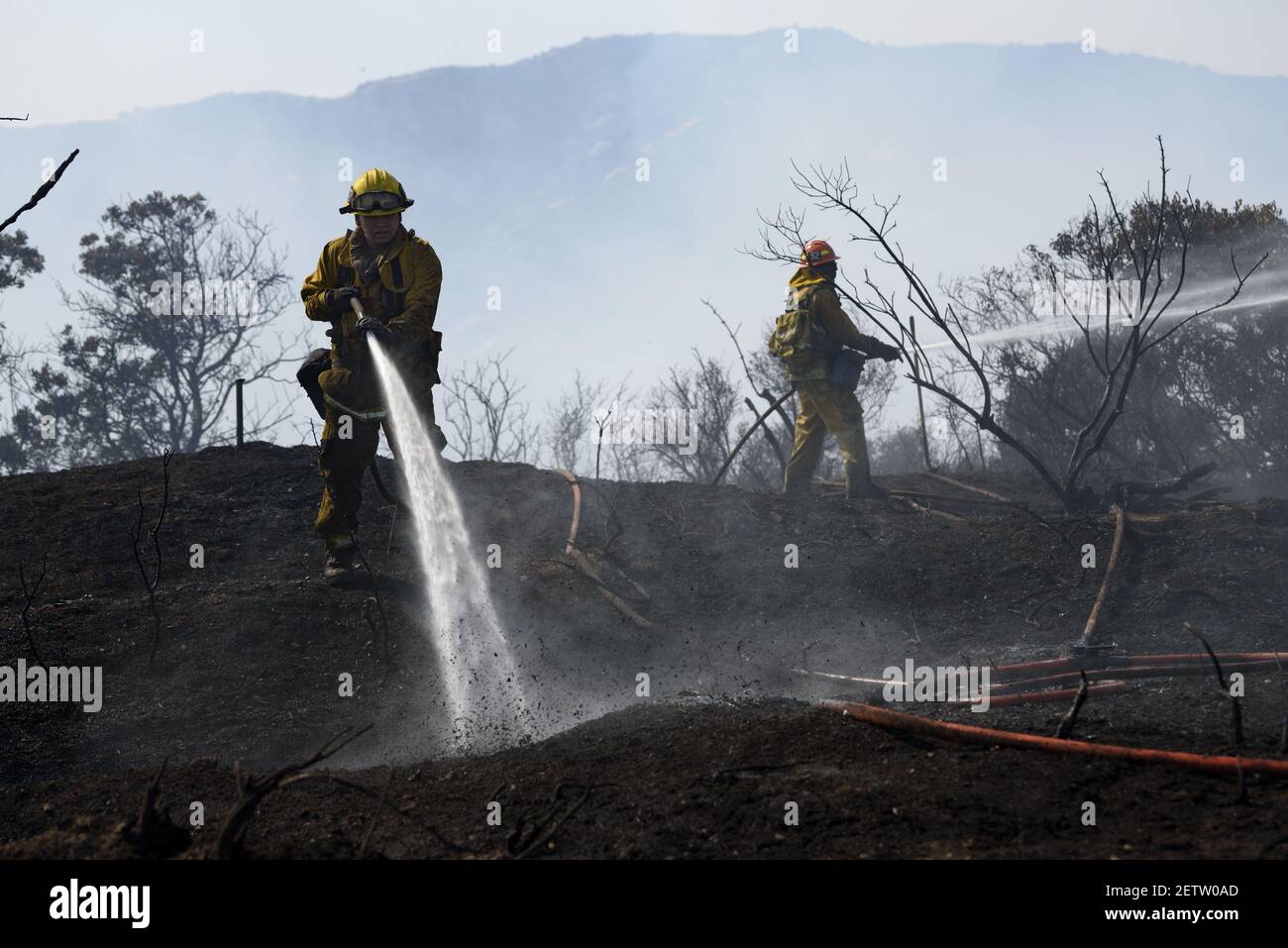 Firefighters battle a wildfire in Mandeville Canyon near the Getty ...