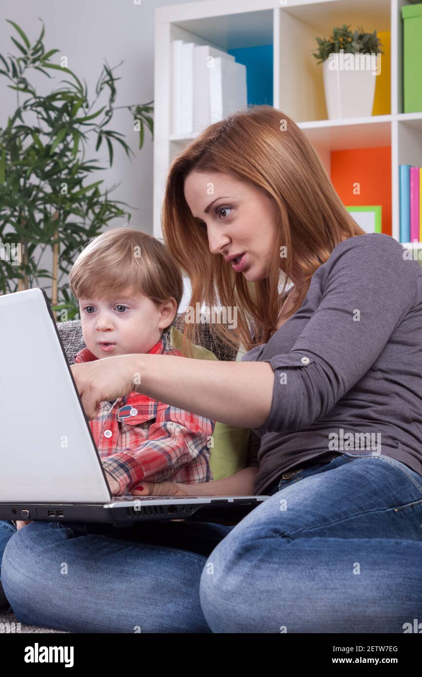 Mother pointing on the computer with son Stock Photo - Alamy