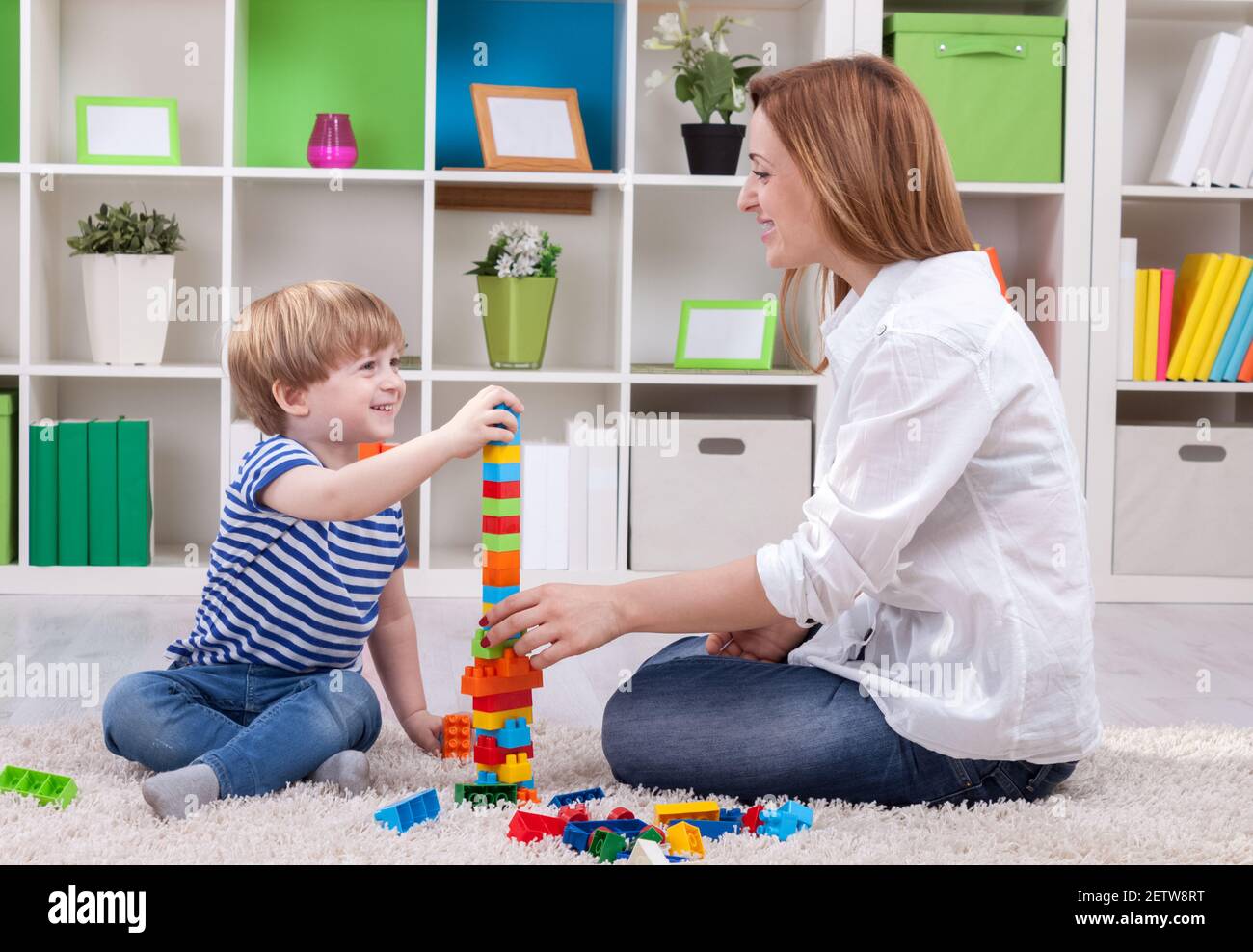 Mother and child build toy tower succes Stock Photo - Alamy