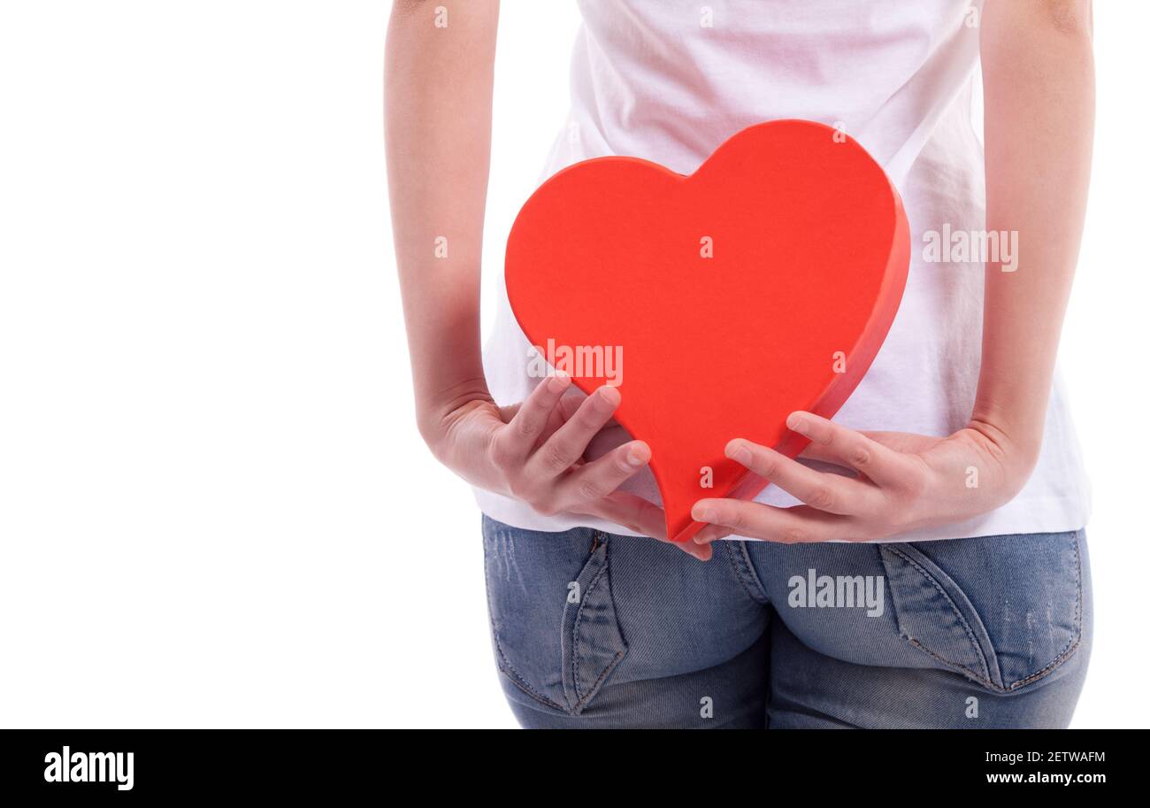 Girl holding heart behind back Stock Photo - Alamy