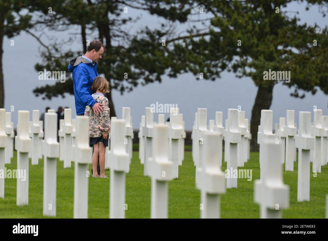 Visitors view the graves of fallen soldiers at the Normandy American ...