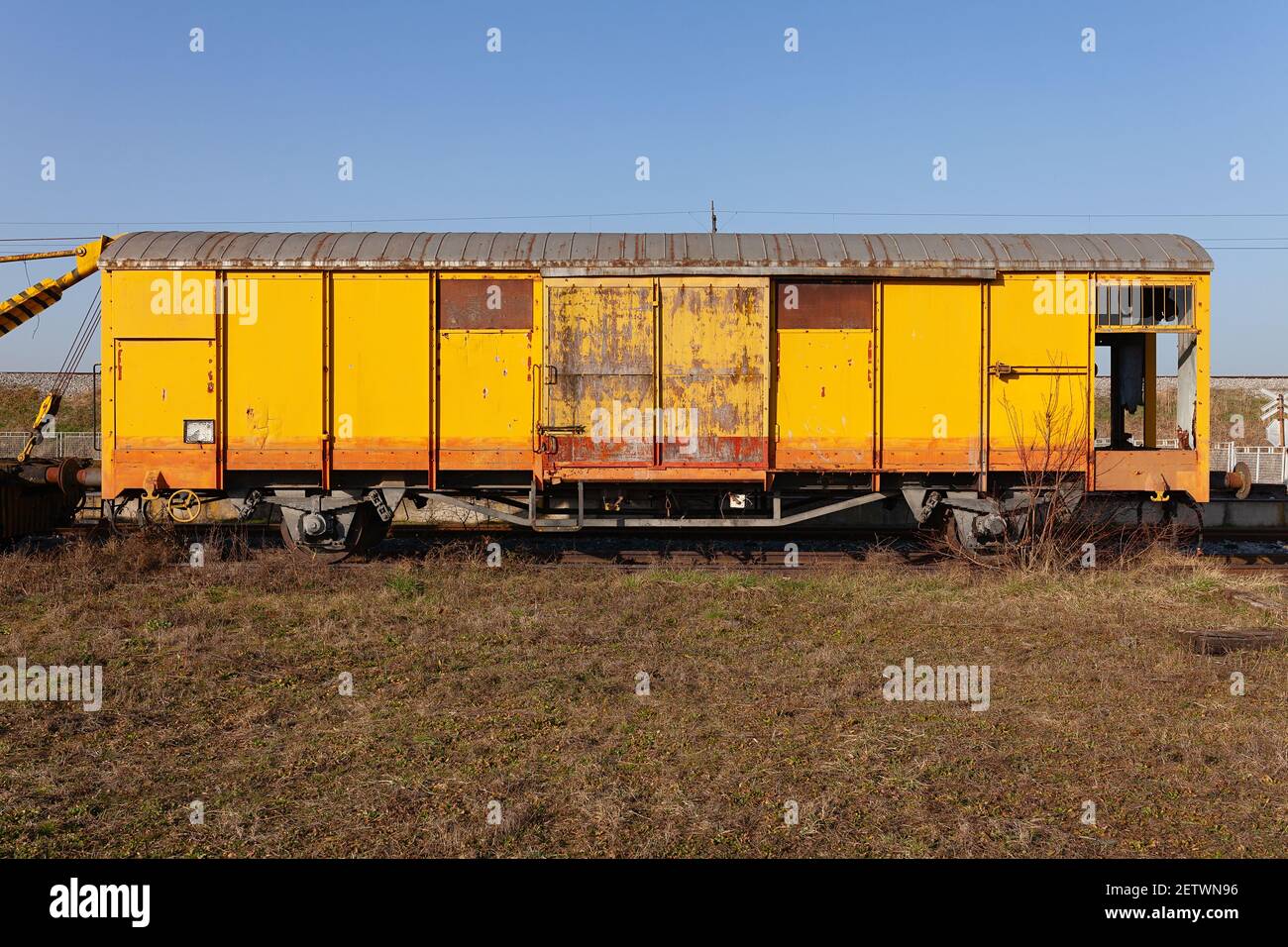 Old yellow cargo train wagon, grungy and weathered on the abandoned ...