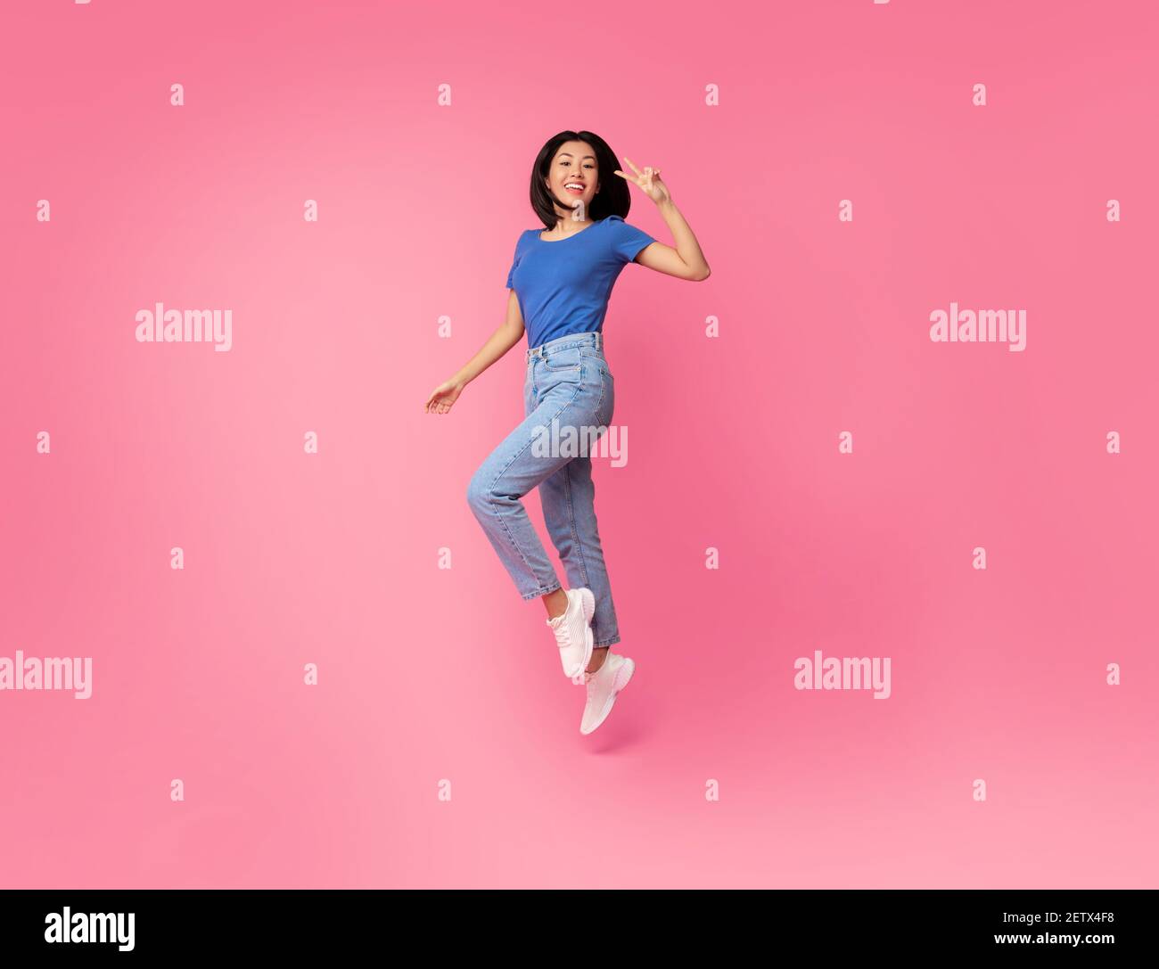 Happy young asian lady jumping at studio celebrating victory Stock ...