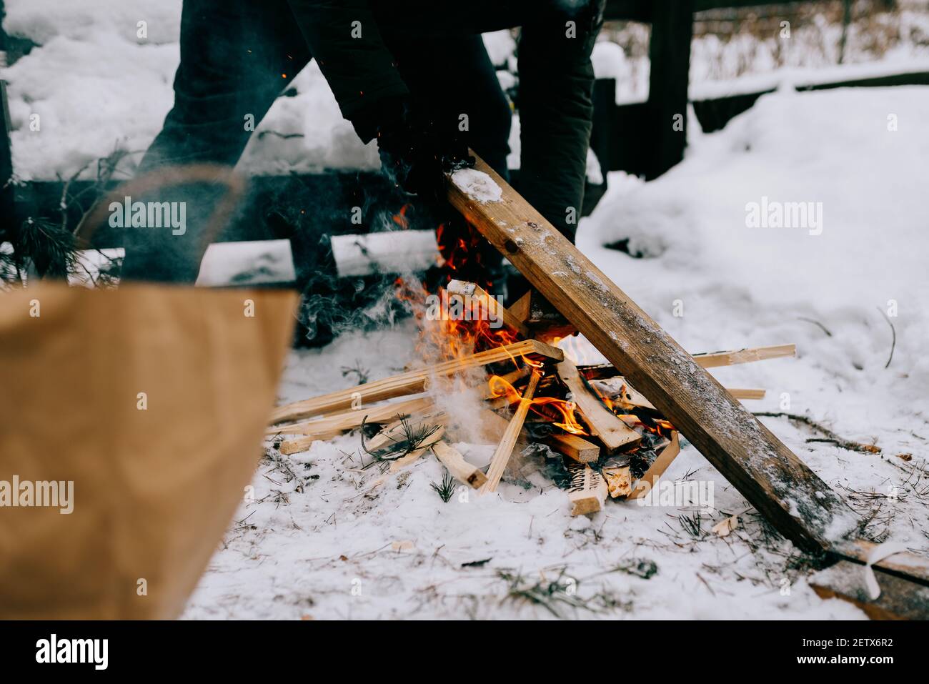 Lighting a fire in the forest in winter Stock Photo - Alamy