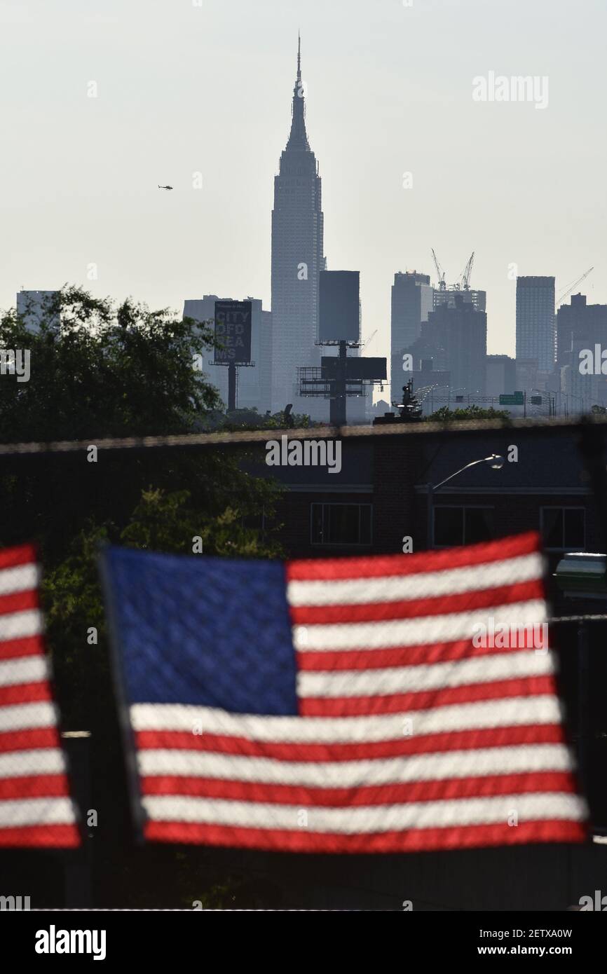 American flags are tied to a chain link fence on a highway overpass in ...
