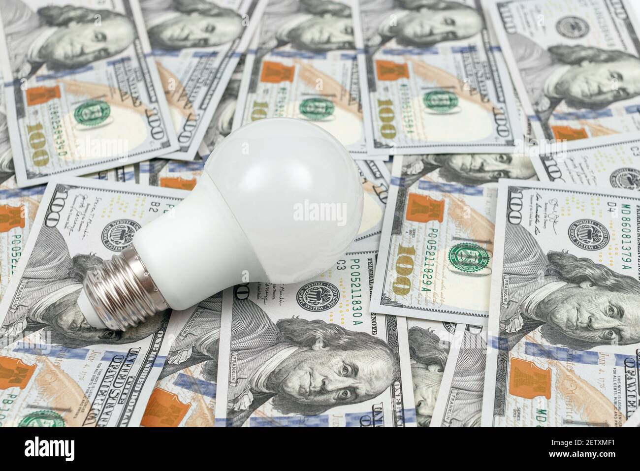 Energy Efficient Light Bulb on money background. Energy saving concept ...