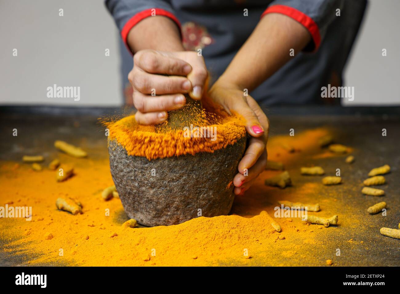 Woman hand powdering Indian spices turmeric powder splash explosion ...