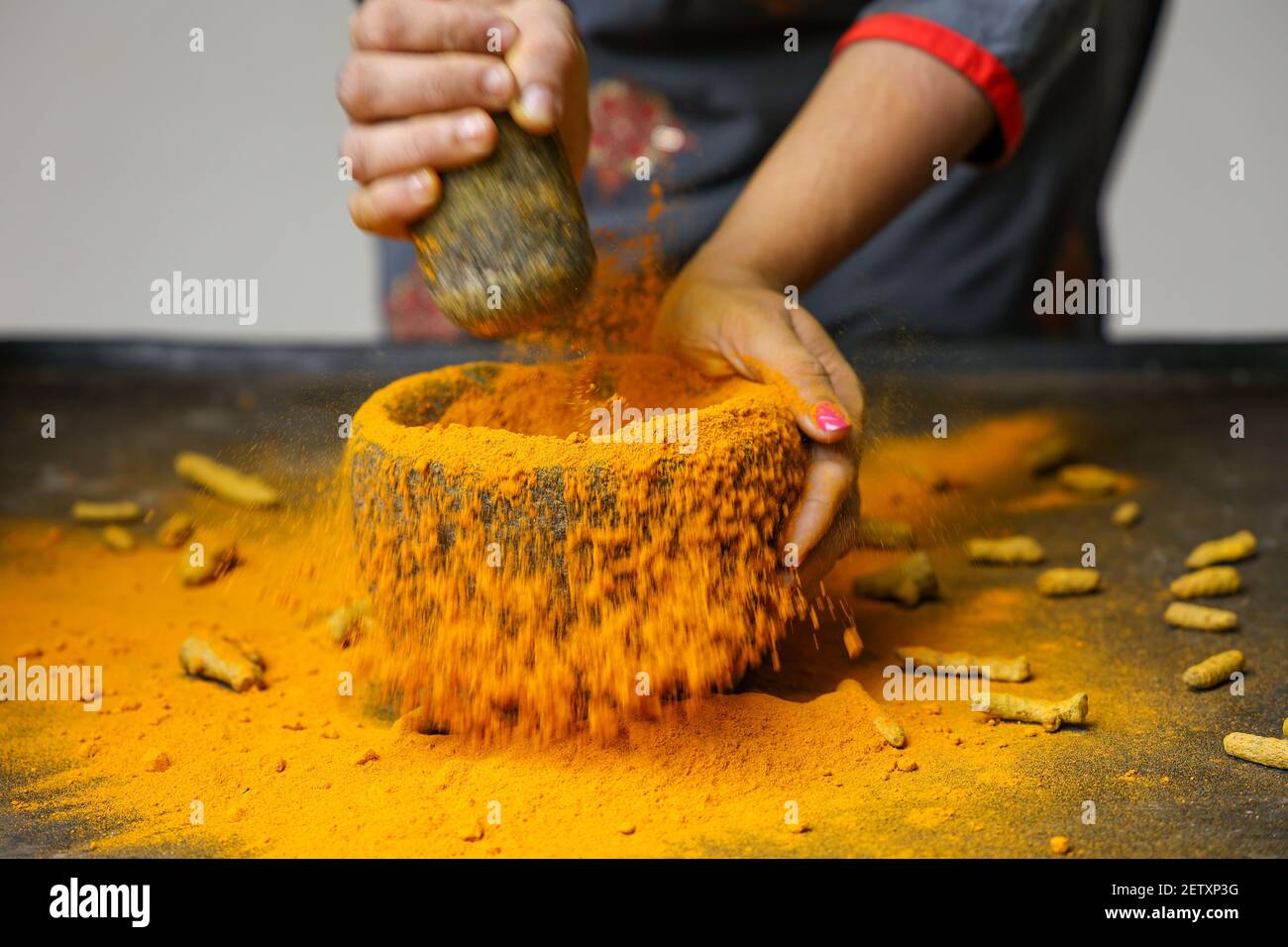 Woman hand powdering Indian spices turmeric powder splash explosion ...