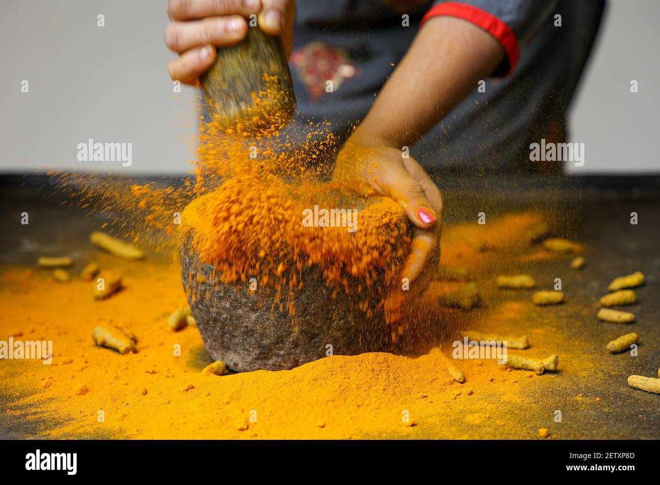 Woman hand powdering Indian spices turmeric powder splash explosion ...