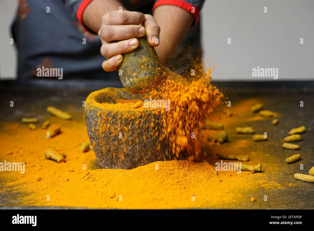 Woman hand powdering Indian spices turmeric powder splash explosion ...