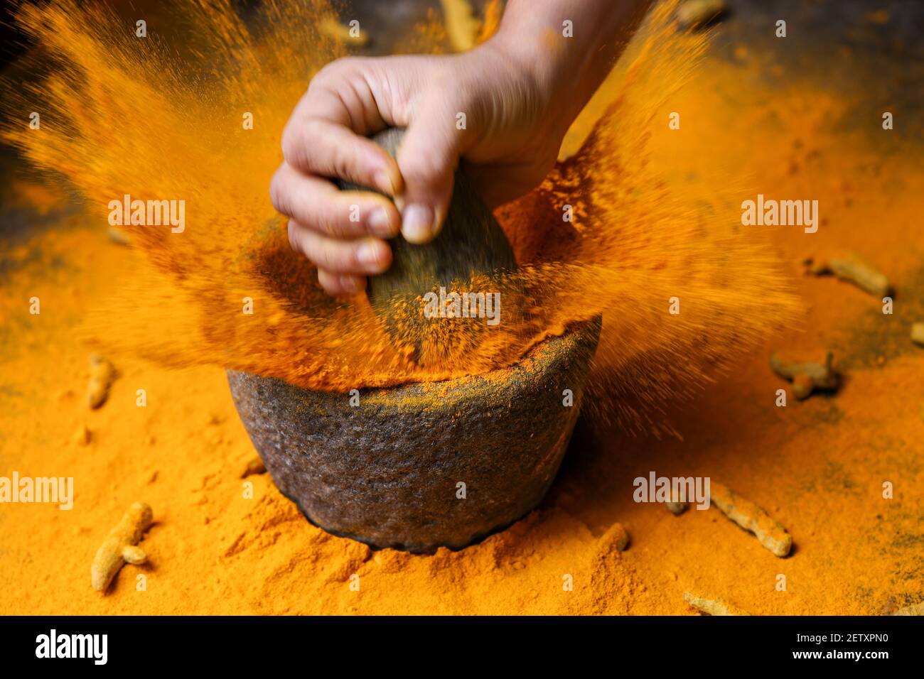 Woman hand powdering Indian spices turmeric powder splash explosion ...