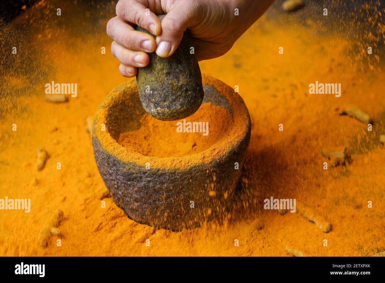 Woman hand powdering Indian spices turmeric powder splash explosion ...