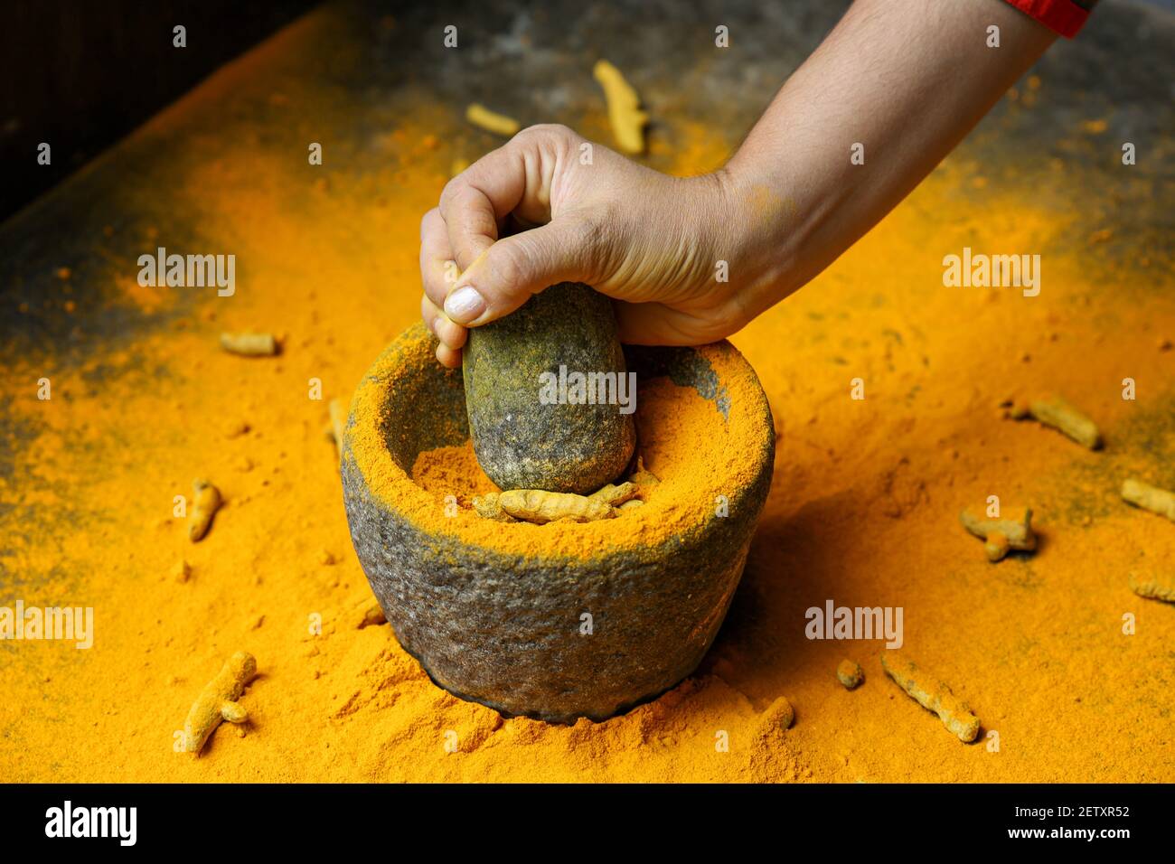 Woman hand powdering Indian spices turmeric powder splash explosion ...