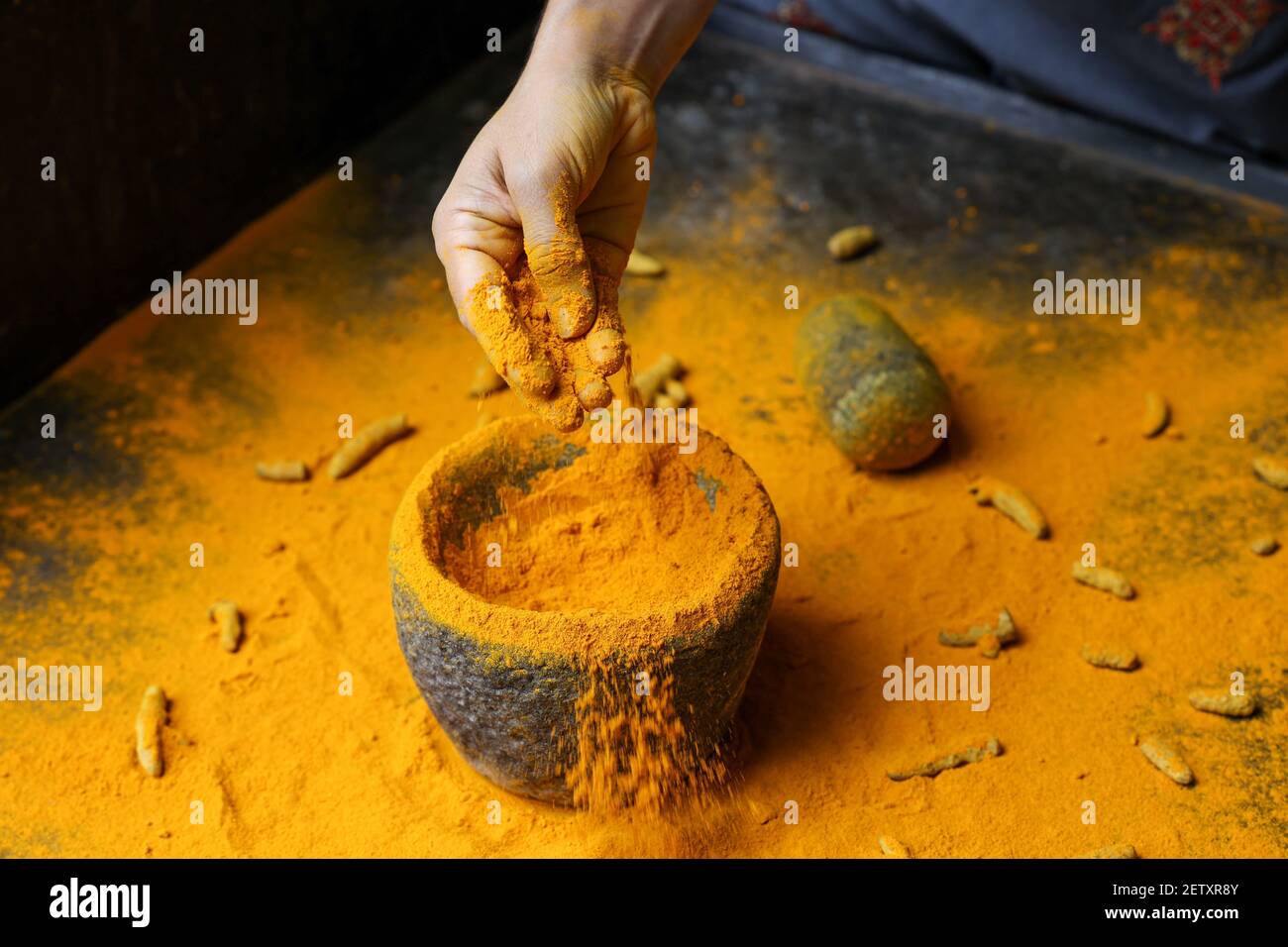 Woman hand powdering Indian spices turmeric powder splash explosion ...