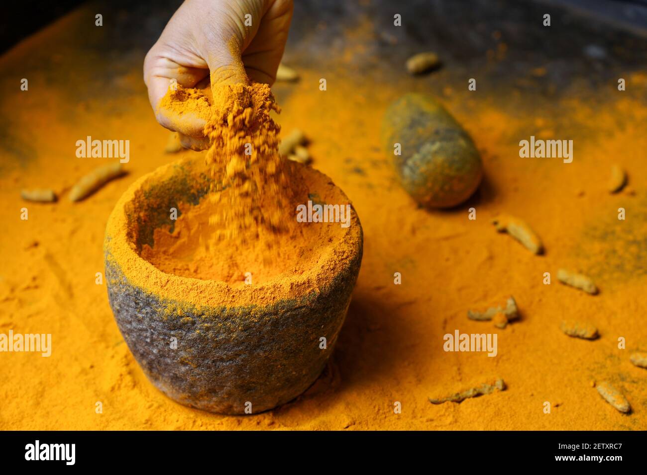 Woman hand powdering Indian spices turmeric powder splash explosion ...
