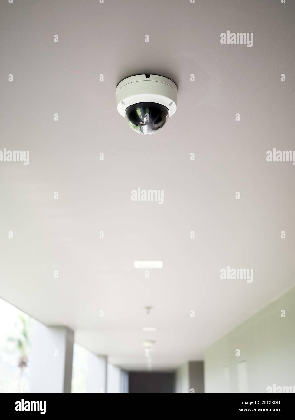 CCTV camera on white ceiling at walkway on ground floors in apartment ...