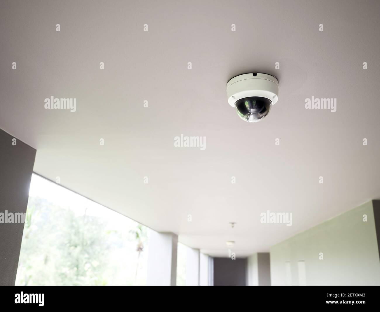CCTV camera on white ceiling at walkway on ground floors in apartment ...