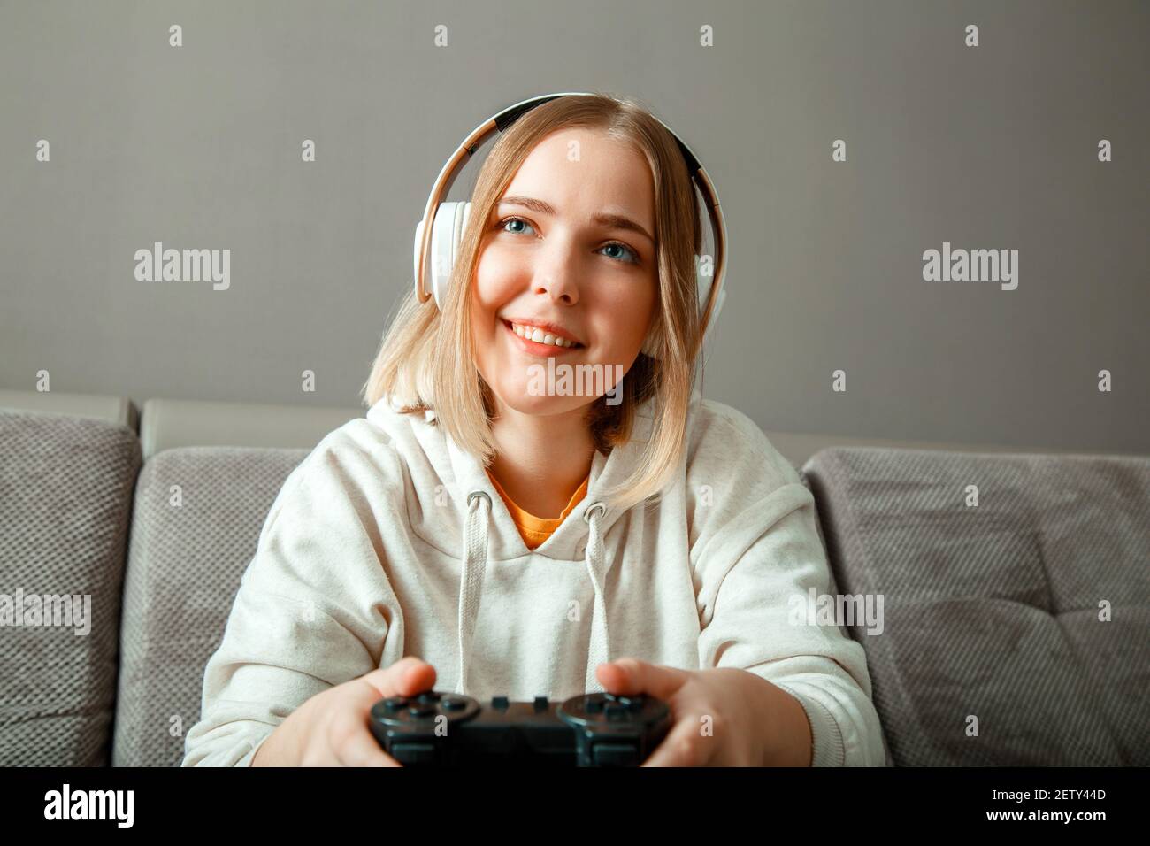 Happy young woman player wins in game console while playing video game ...