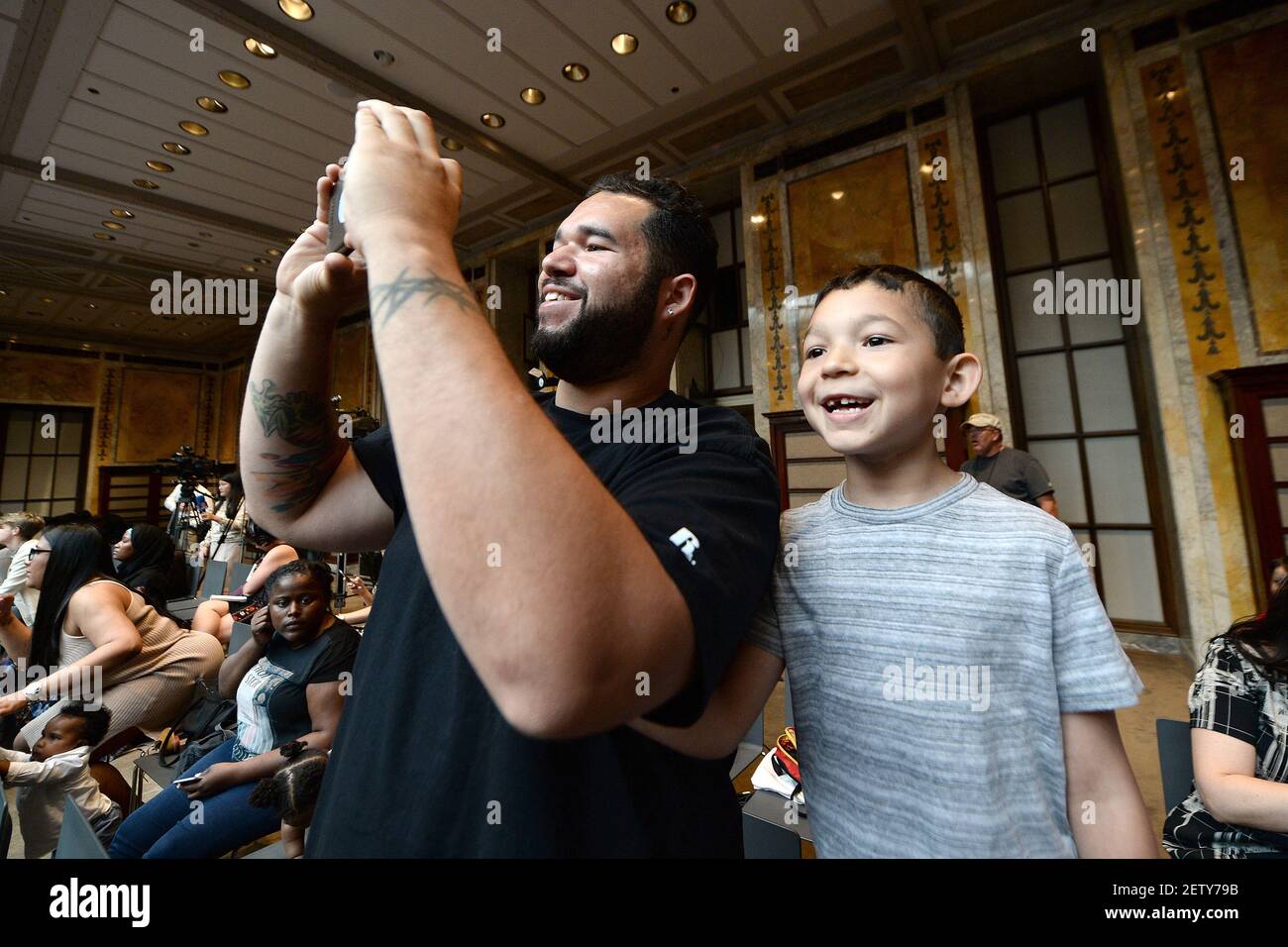 (L-R) Joshua Santiago and his son Jesse Santiago, 5, look on as Mrs. Santiago receives her ...