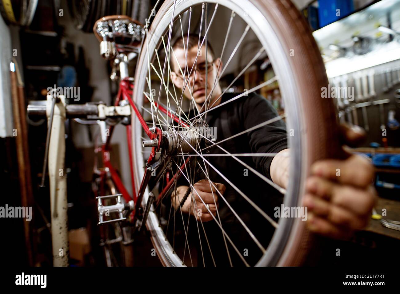 Professional young man adjusting bicycle wheel wires Stock Photo - Alamy