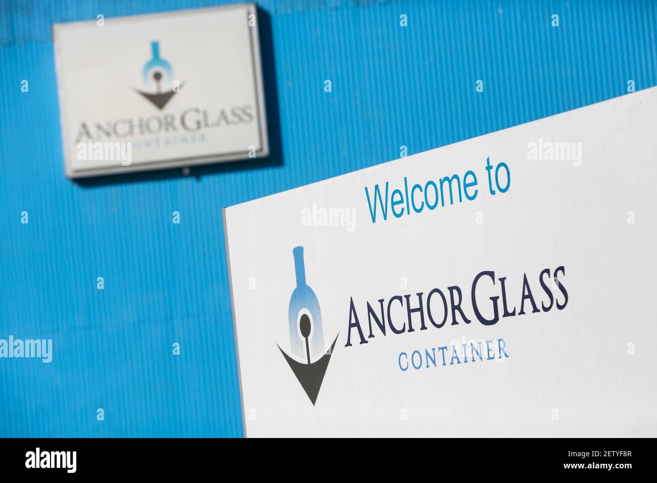 A logo sign outside of a facility occupied by Anchor Glass Container ...