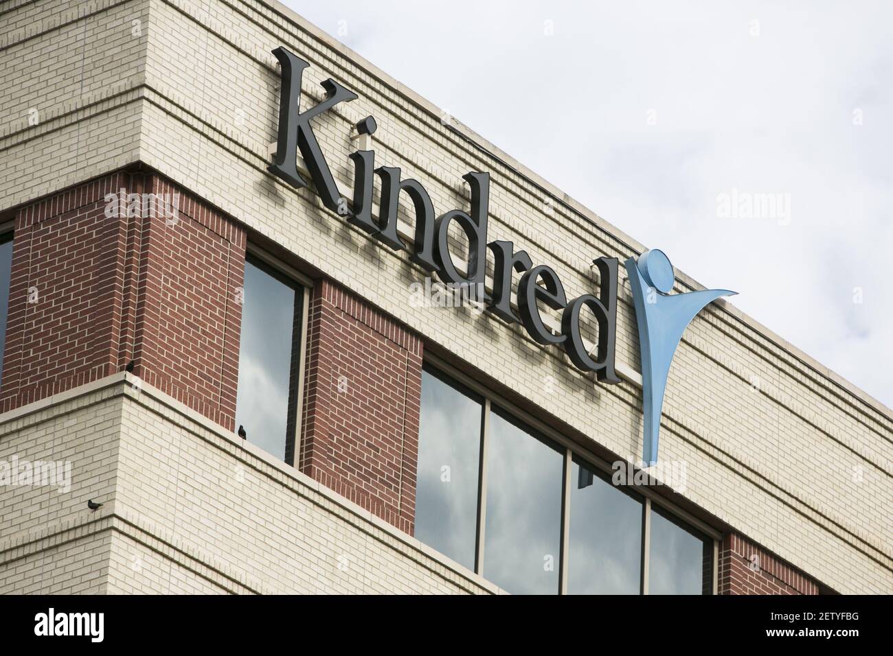 A logo sign outside of the headquarters of Kindred Healthcare in ...