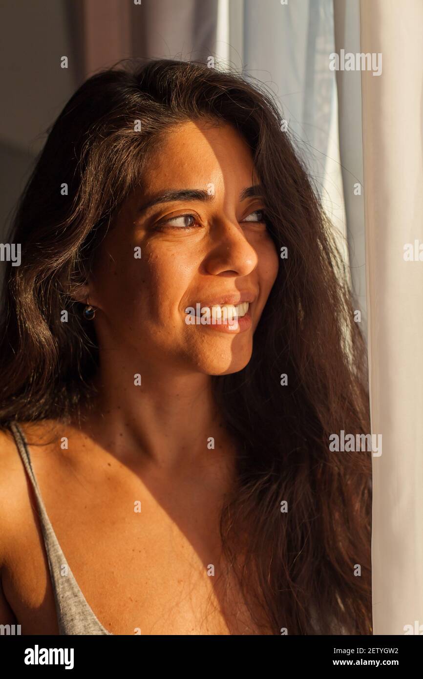 Portrait of smiling woman with black hair, in sunlight. Happy face ...