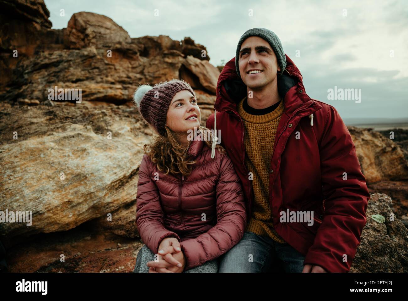 Caucasian girlfriend and boyfriend sitting on mountain smiling bonding ...