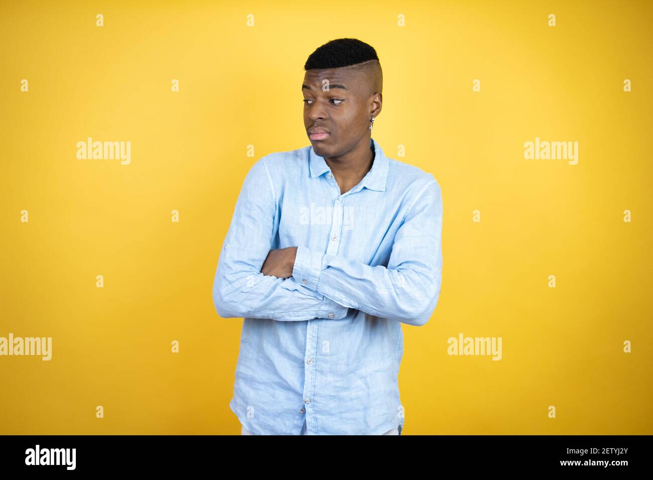 Young african american man wearing a casual shirt standing over yellow ...