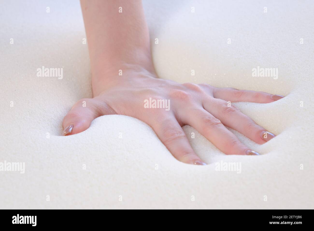a woman's hand presses on the foam rubber close-up checks its softness ...