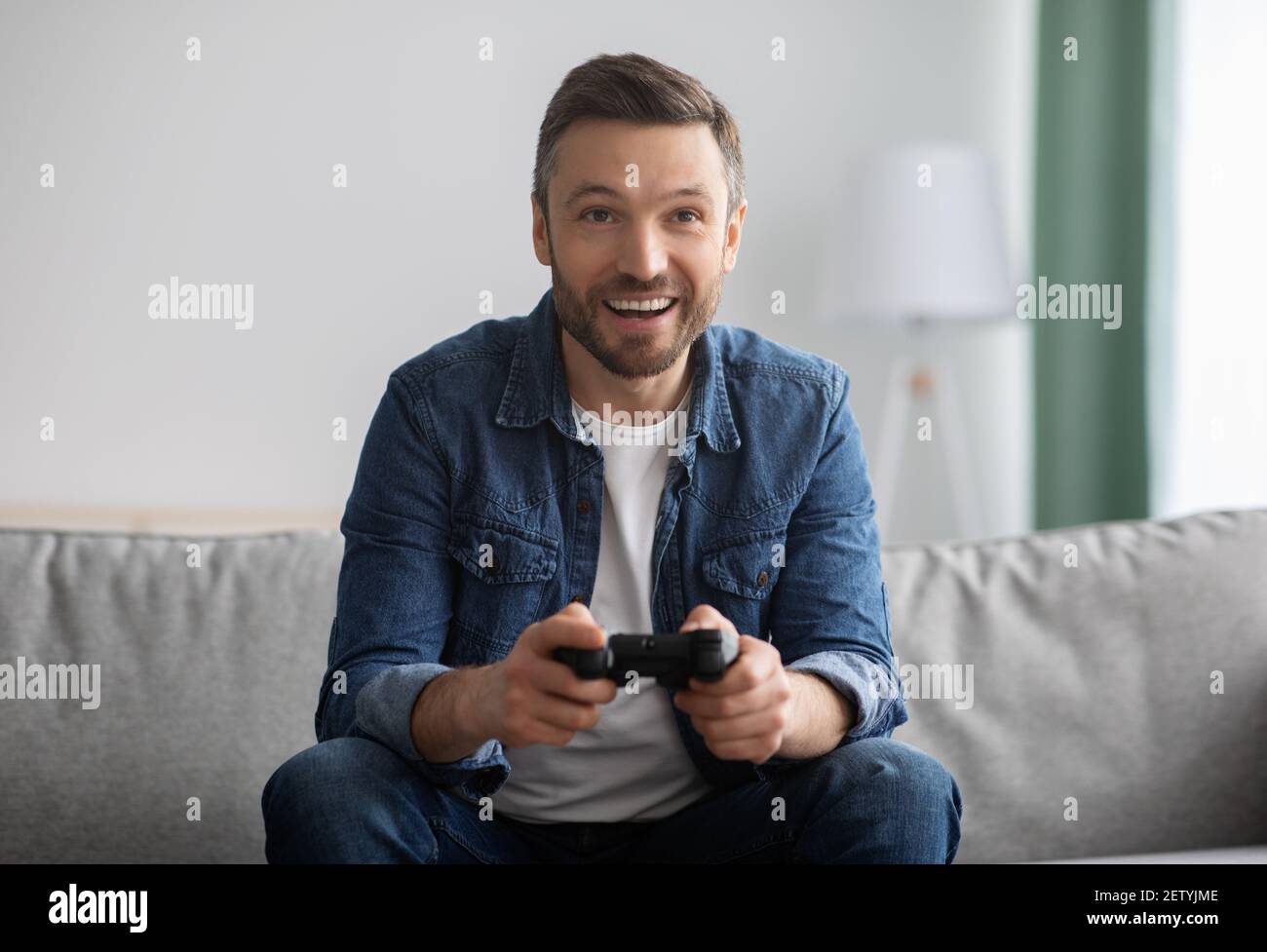 Emotional middle-aged man playing video games at home Stock Photo - Alamy