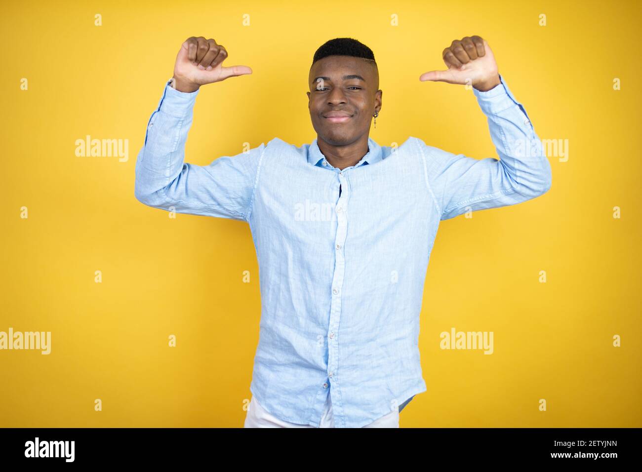 Young african american man wearing a casual shirt standing over yellow ...